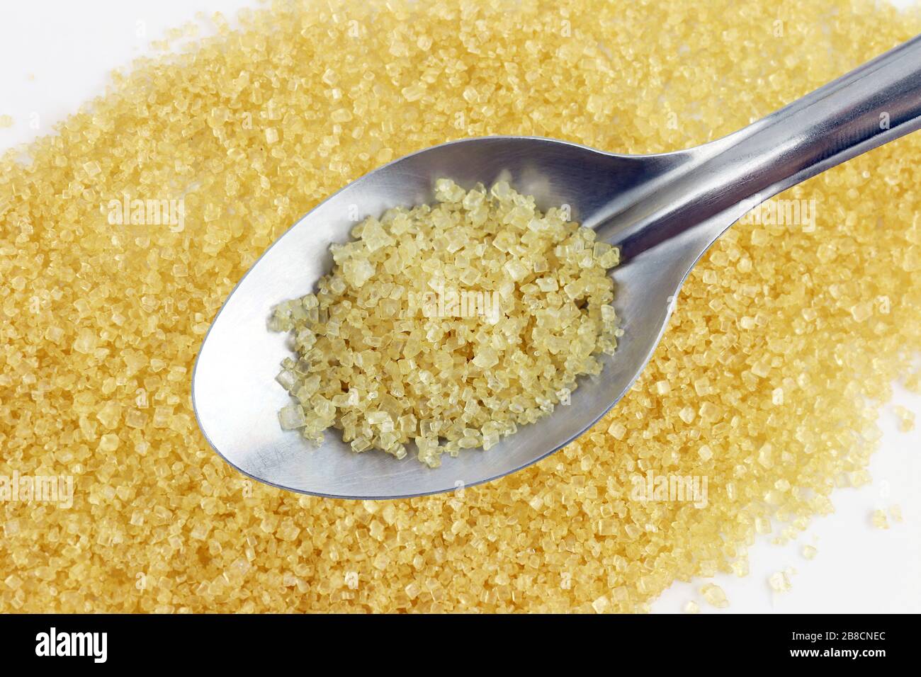 Sugar in spoon, sugarcane on spoon stainless steel and granulated sugar ...