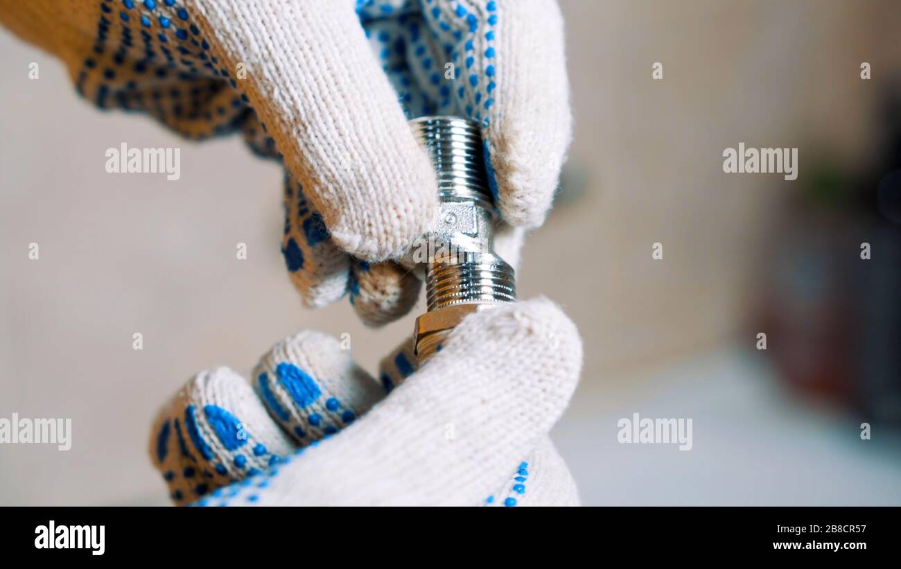 Close up of A man is sealing tape wrap around iron water tap screw ...
