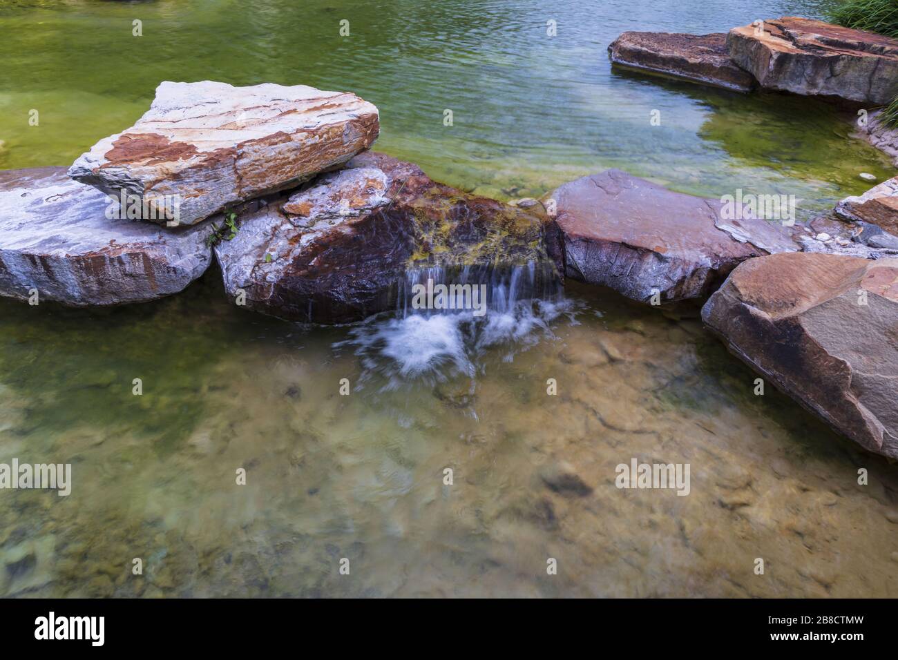 Beautiful view of pond decorated with big rocks. Clear water mirror ...