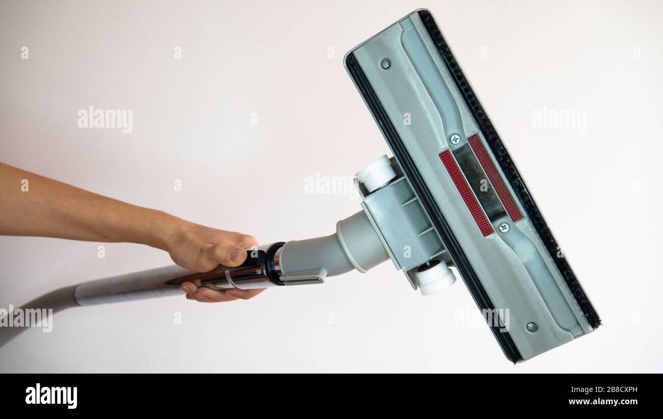 Close up of the vacuum cleaner, focus on the brush in a woman's hand on ...