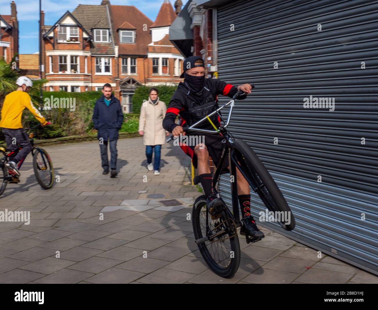 A boy does a wheelie on the pavement Stock Photo - Alamy