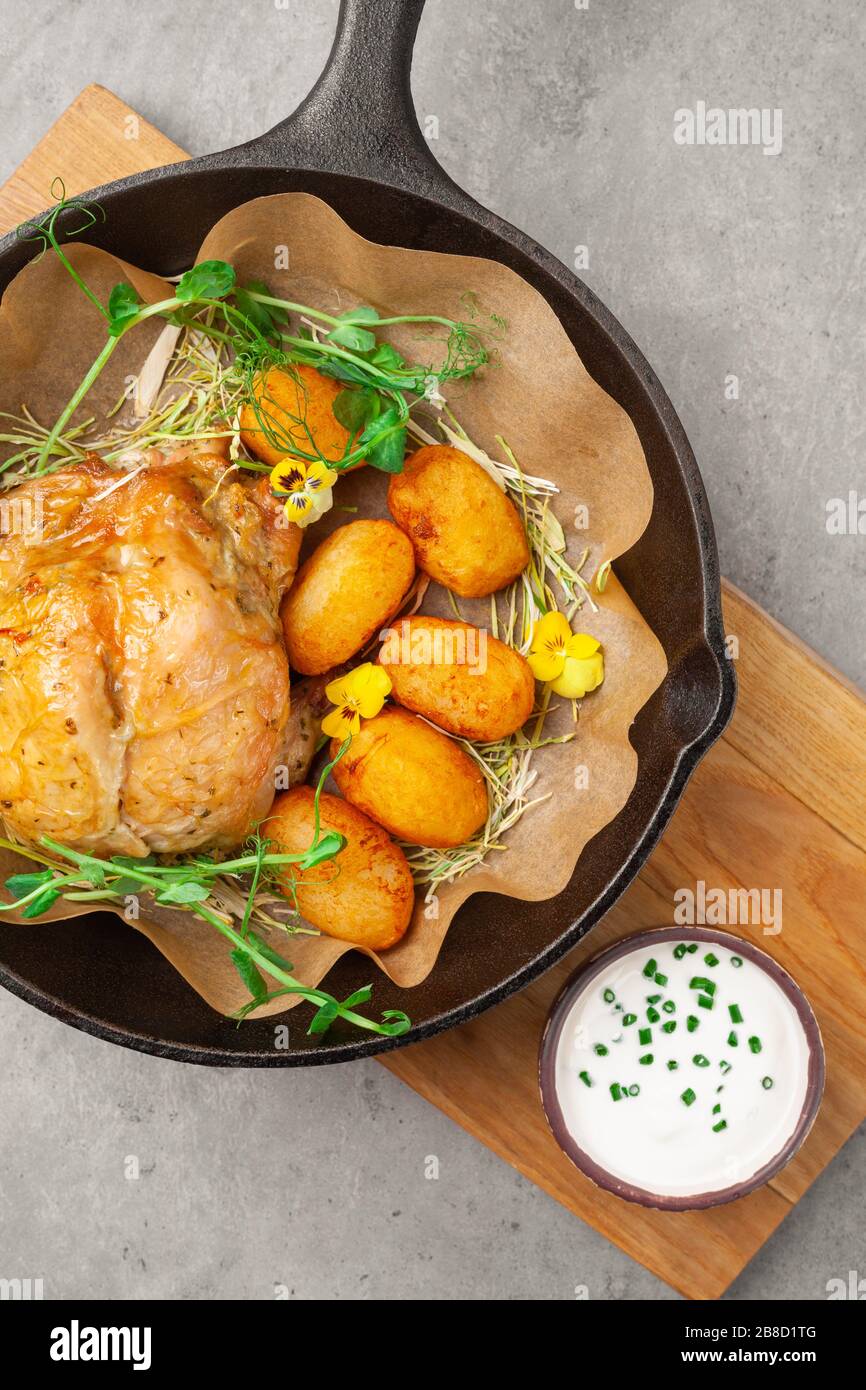 Baked tobacco chicken with potatoes, sour cream, herbs in pan Stock ...
