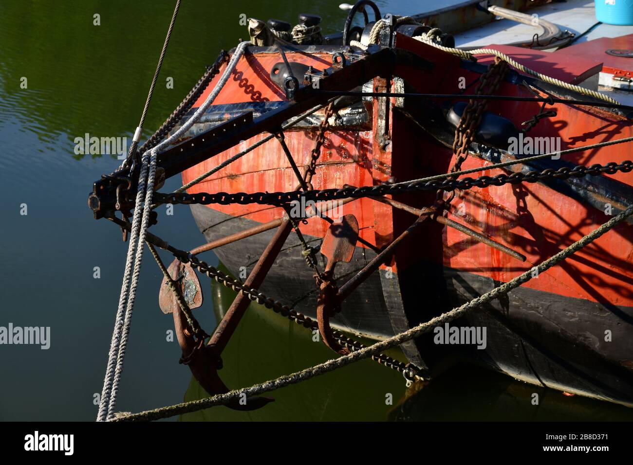 Bow close up of red colored flatbottom boat displaying ropes, cables ...