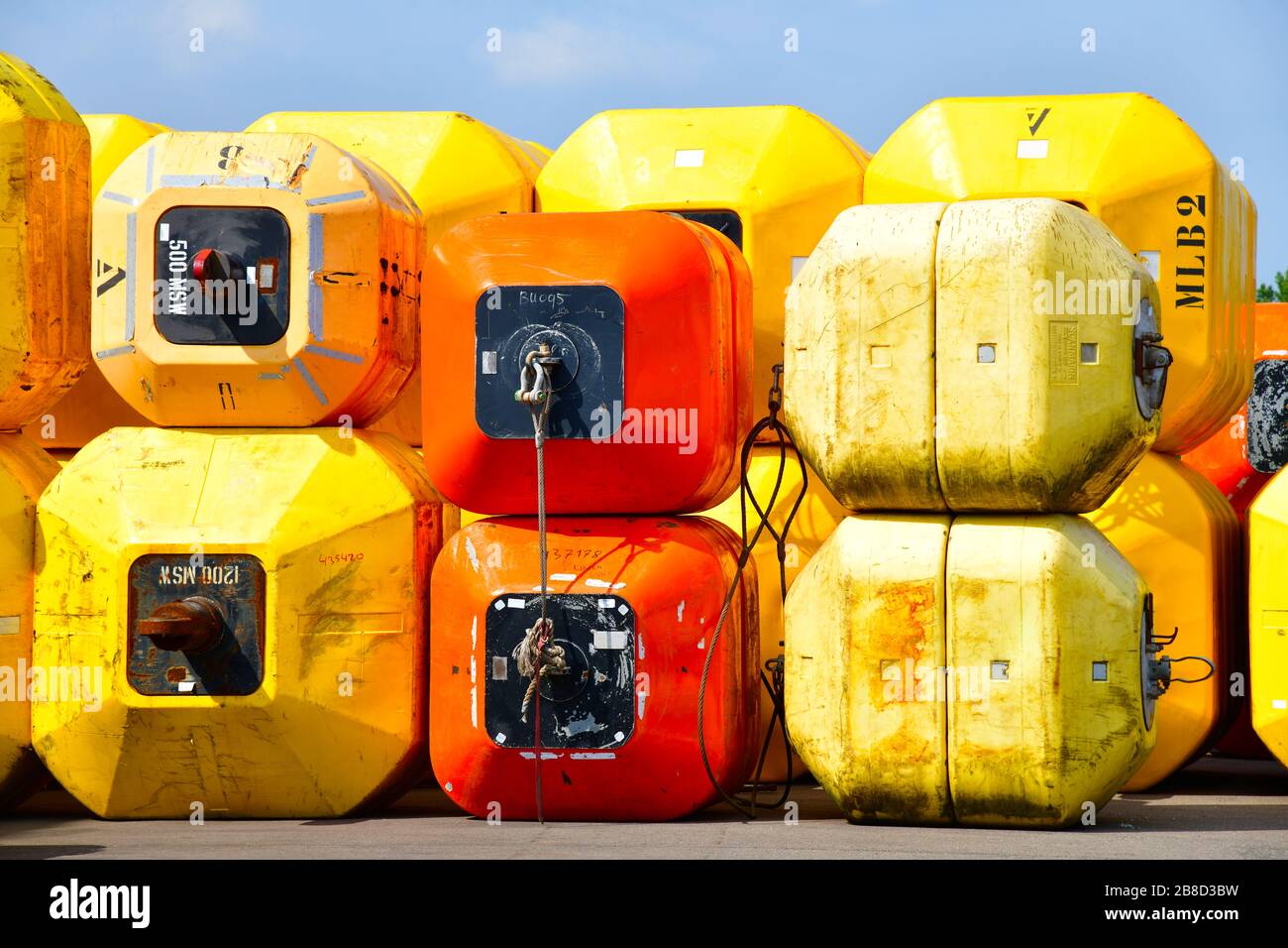 Overview of yellow and orange colored large mooring buoys stacked on ...