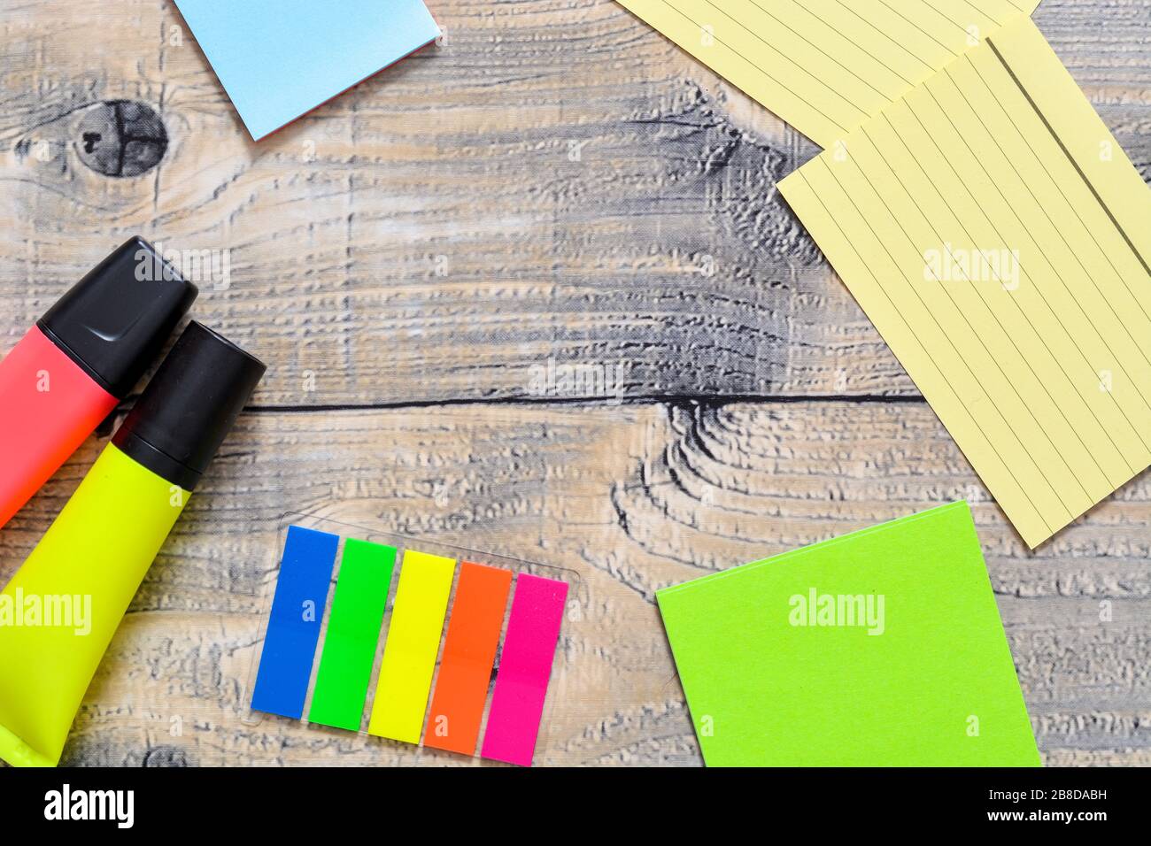 Frame of a desk with post its and a markers on a wooden background ...