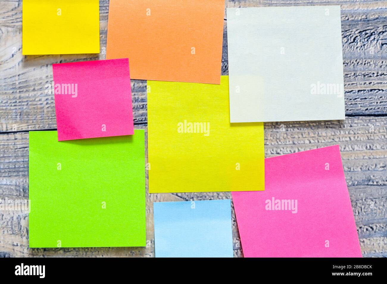 Lots of post its on wooden background with a different symbols on it ...