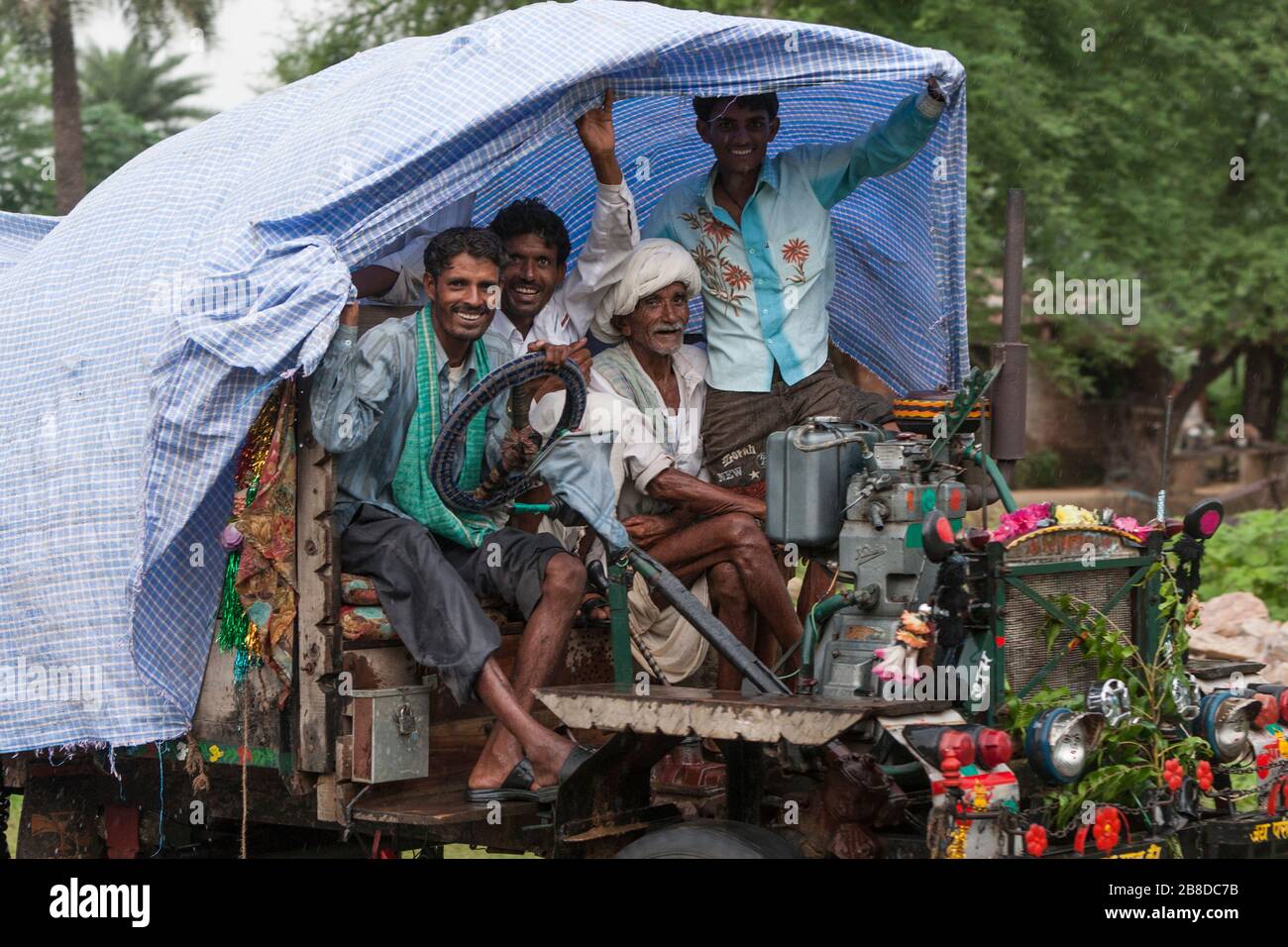 Rickety truck carrying a group of people on a rainy day, Rajasthan ...
