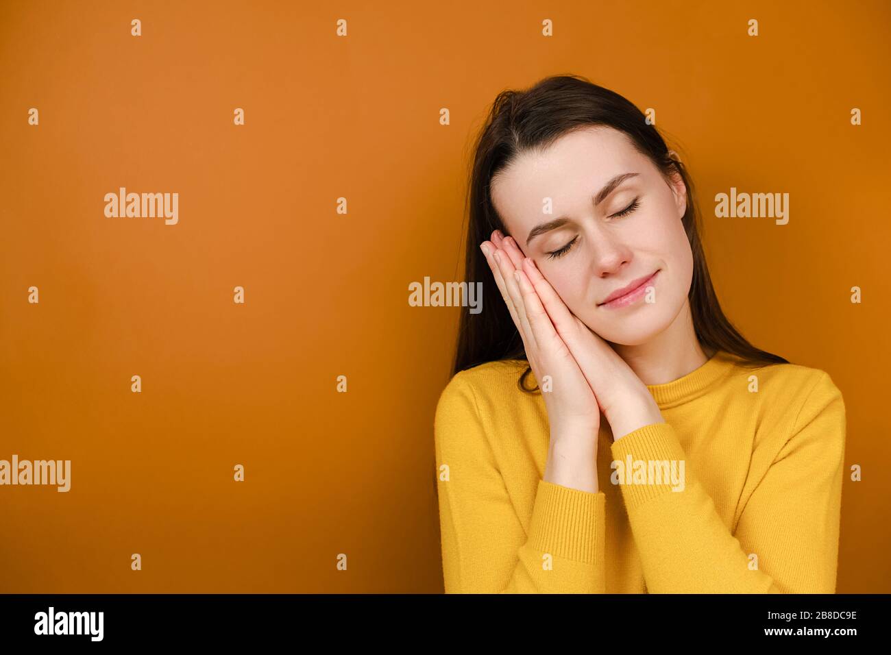 Cheerful young female with happy serene face pretends sleeping, leans ...