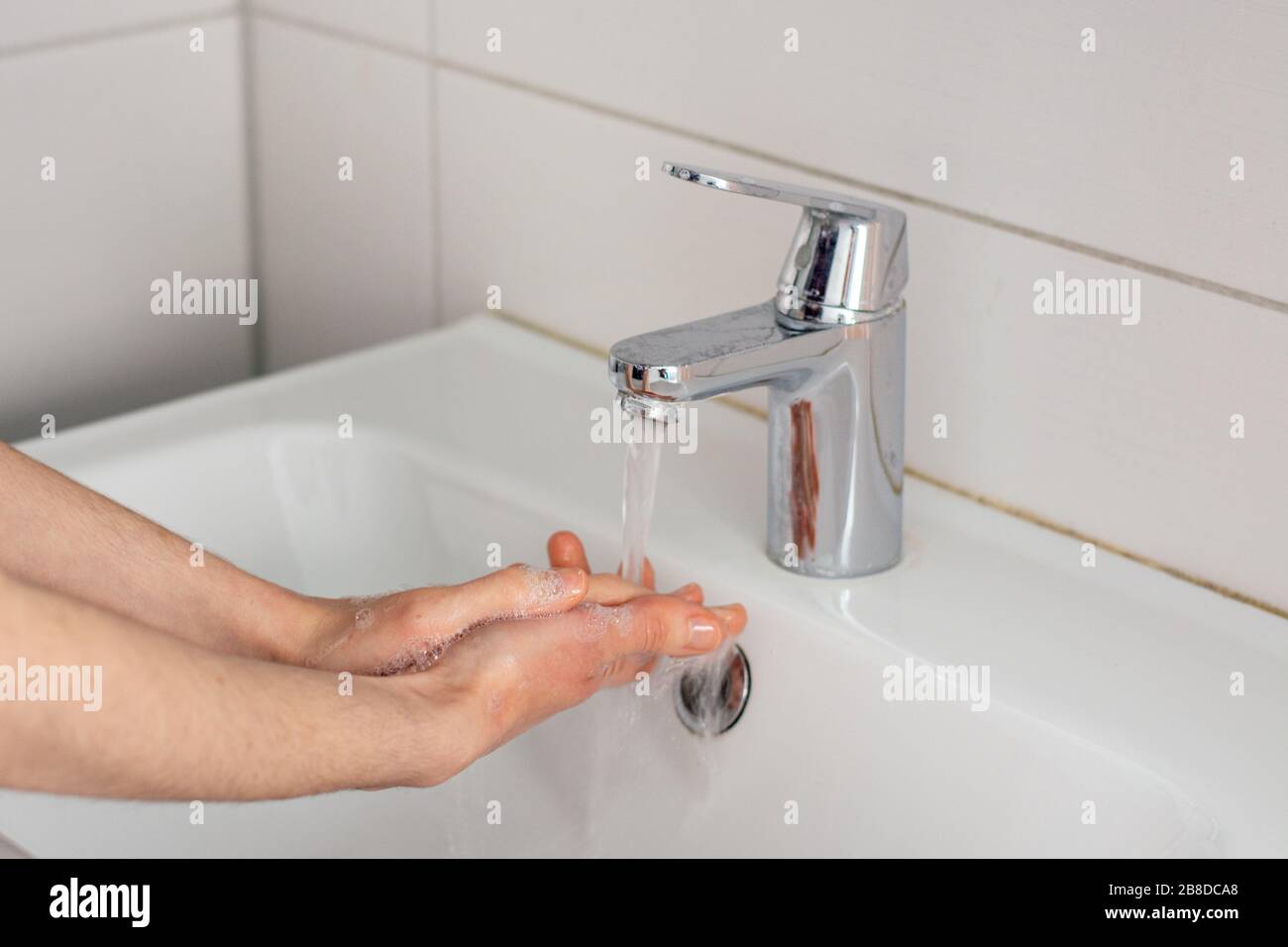 Washing the hands with soap under tap water close up Stock Photo - Alamy