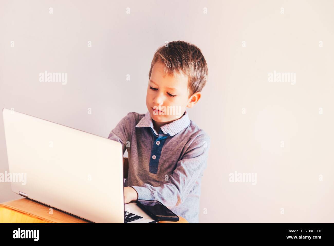 Child working with his computer in his business, concentrated typing to ...