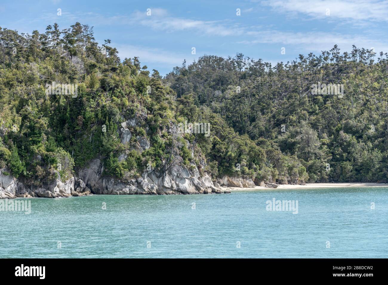 landscape with rocks, sand beach and lush rain forest vegetation, shot ...