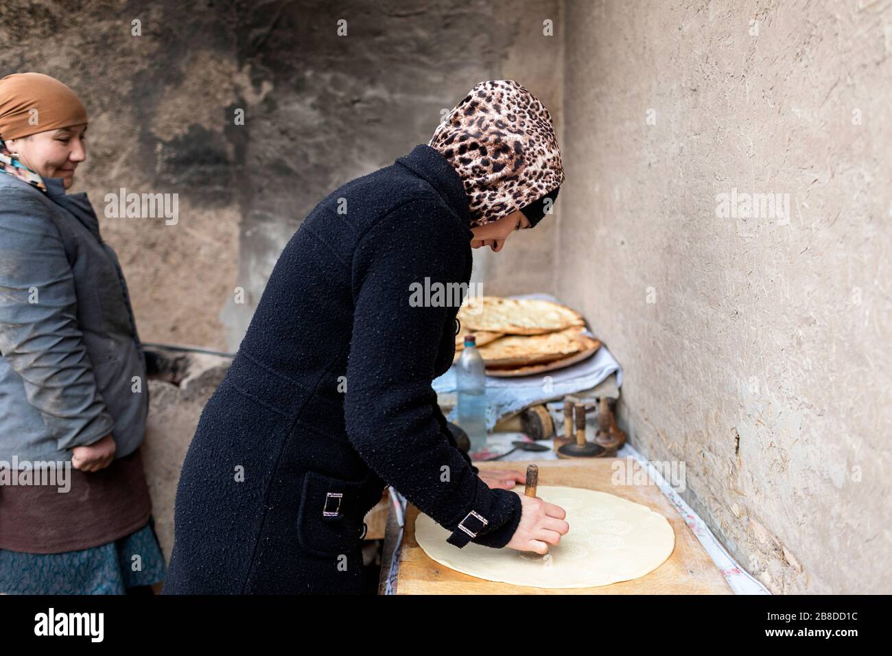 A Local Woman Bakes traditional Bread In A Traditional Clay Oven, Khiva ...