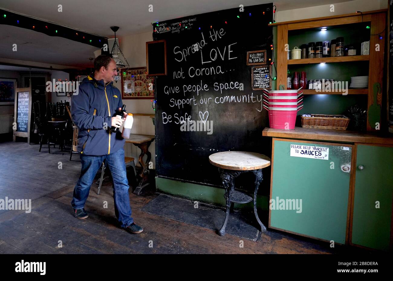 A customer walks past a message board in The Swan Inn pub in Lewes ...