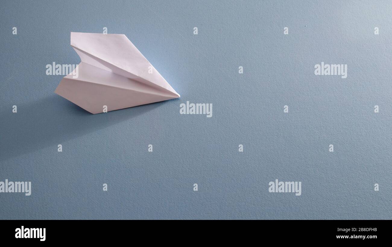 Flat lay white paper plane on blue grey background. Copy space Stock ...