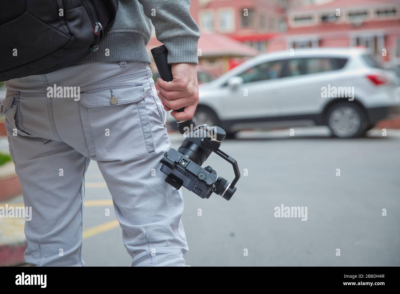 An unidentified man holding gimbal a camera stabilizer . Man holding ...