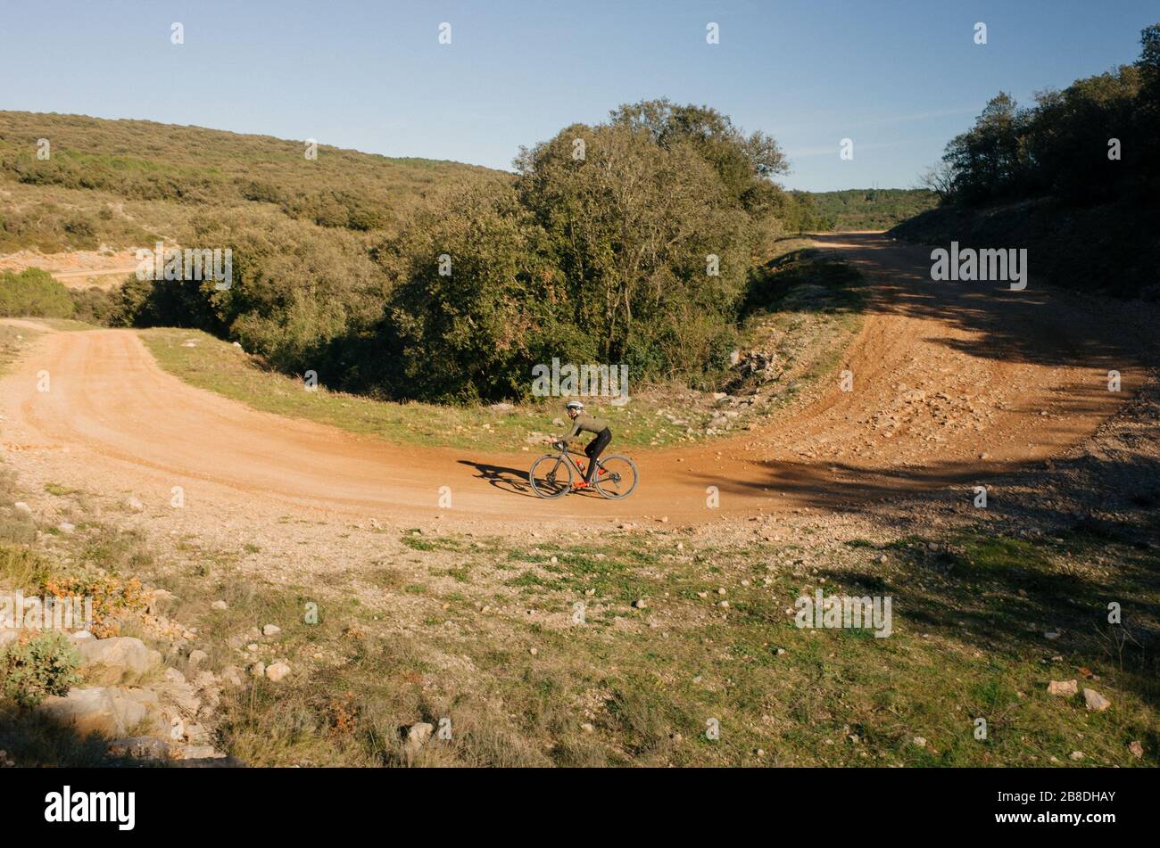 Cyclist rides around a gravel corner in a national park Stock Photo - Alamy