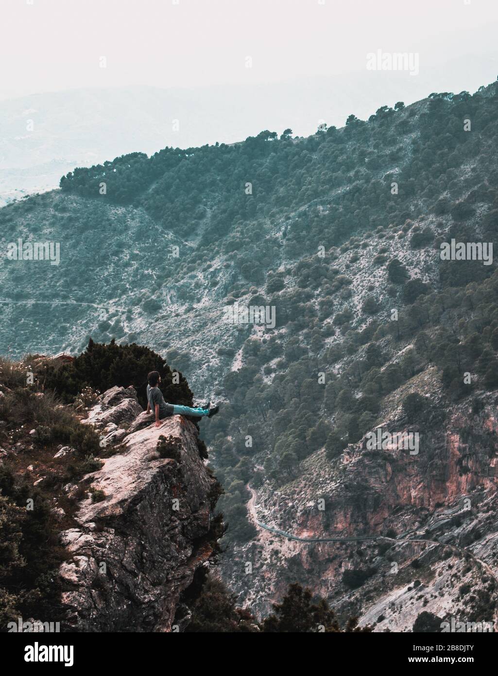 Guy sit down near to the cliff Stock Photo - Alamy