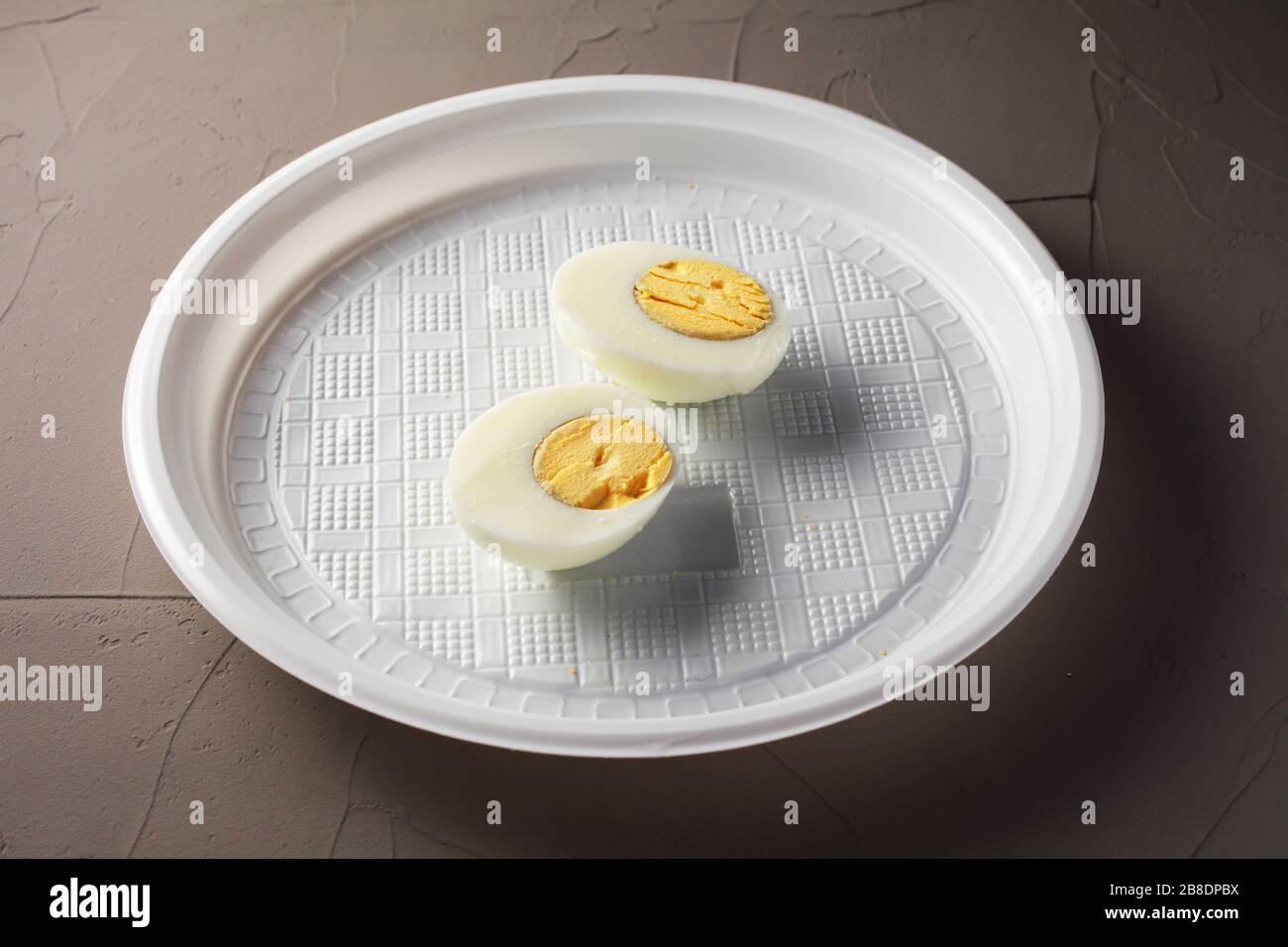 cut egg in a disposable plate on a concrete background Stock Photo - Alamy