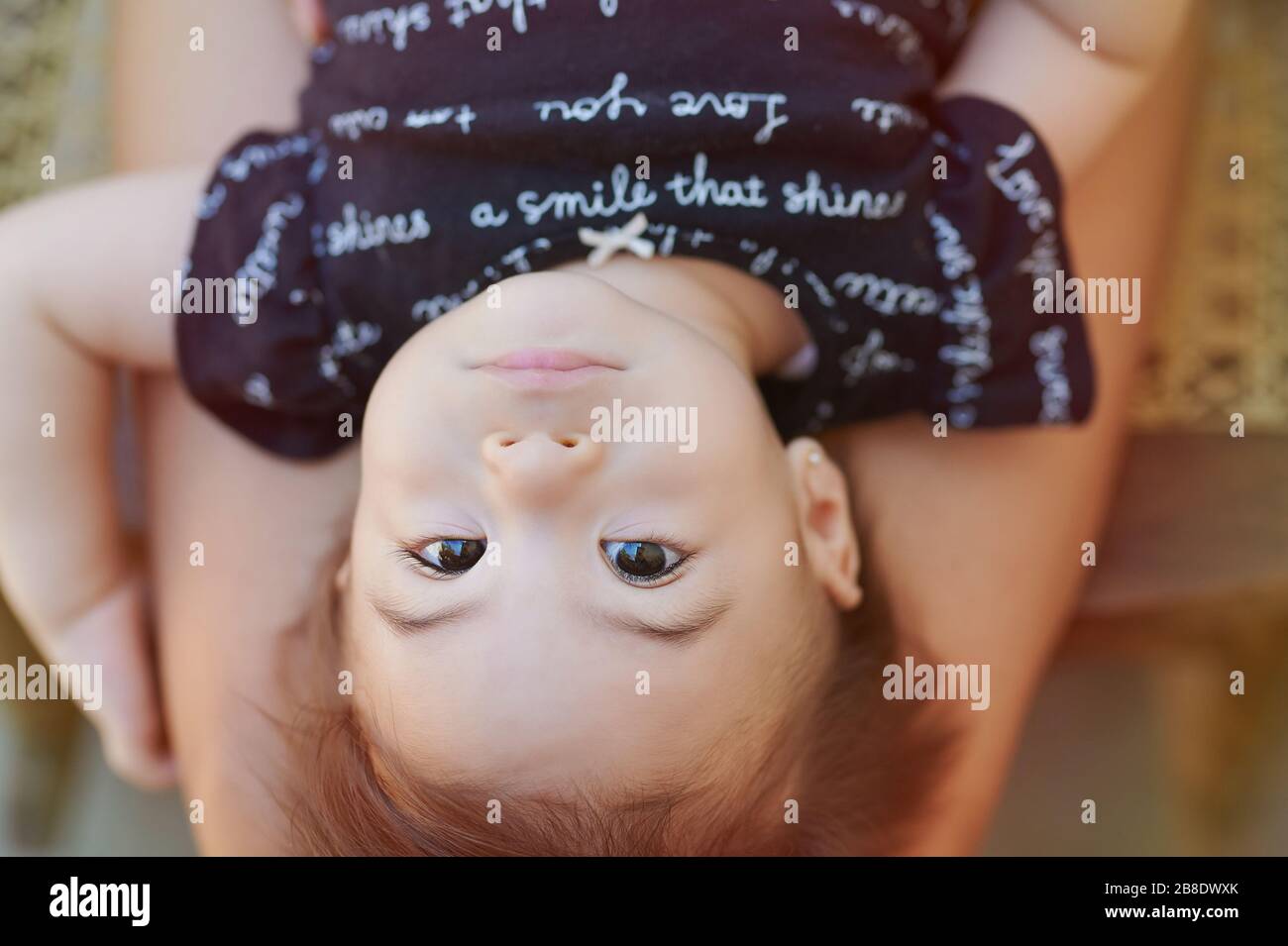 Adorable kid lay on laps above top view close up Stock Photo - Alamy