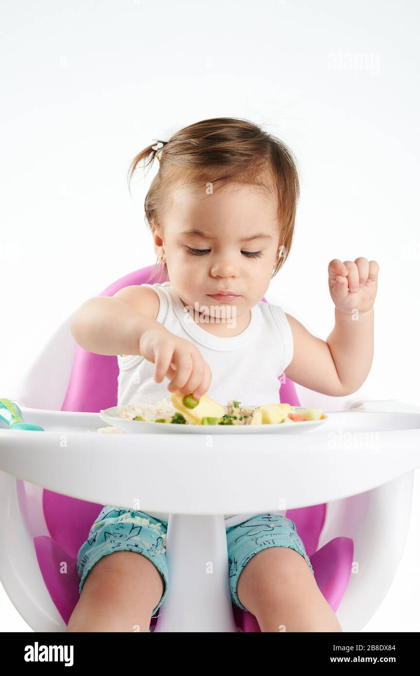 Bbay girl pick food from plate isolated on white studio background ...