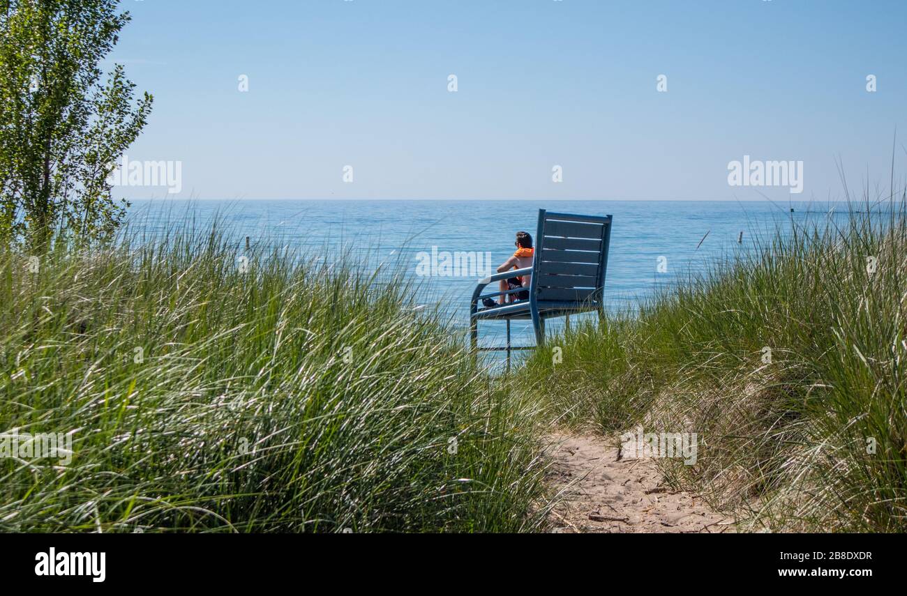 Sitting on an oversized bench at the beach in Kincardine, a man looks ...