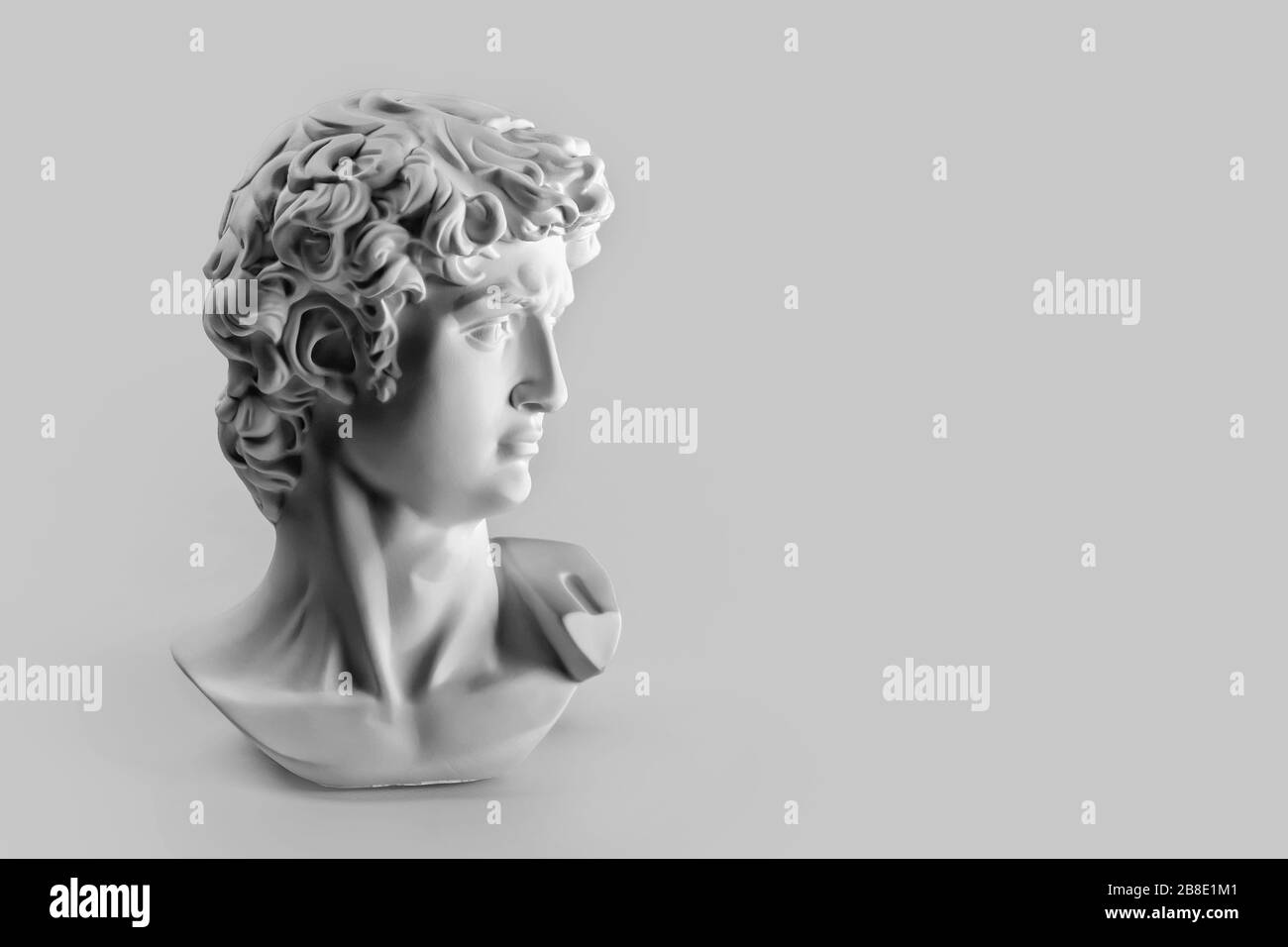 Gypsum statue of David's head. Michelangelo's David statue plaster copy on grey background with ...