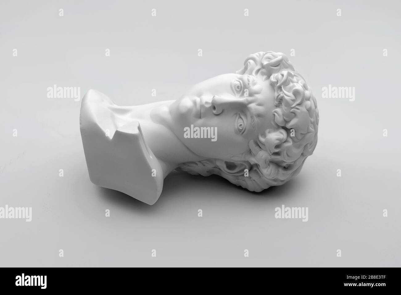 Gypsum bust, statue of David's head. Michelangelo's David statue plaster copy on grey background ...