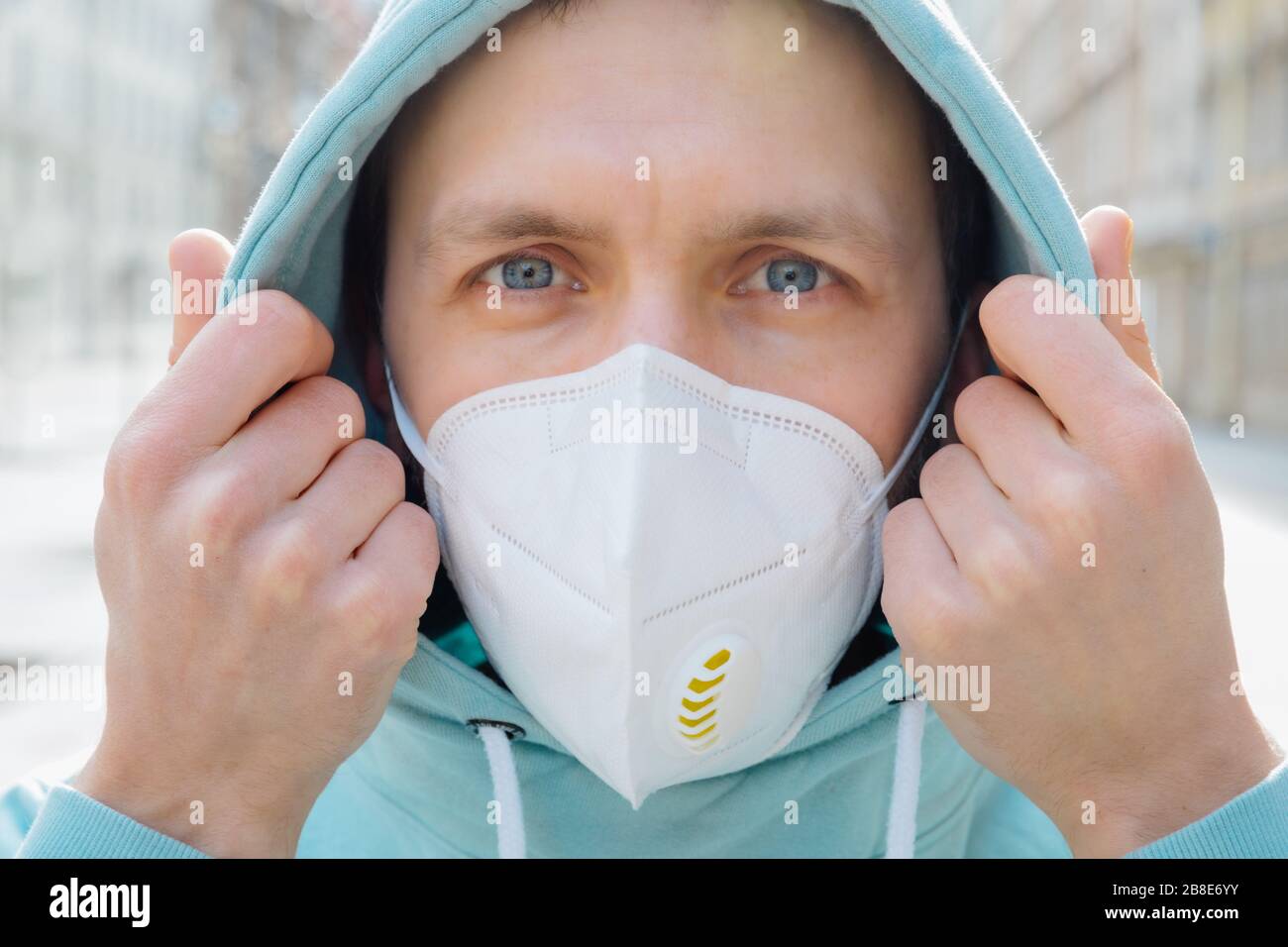 Close up shot of European man protects face with respiratory mask ...