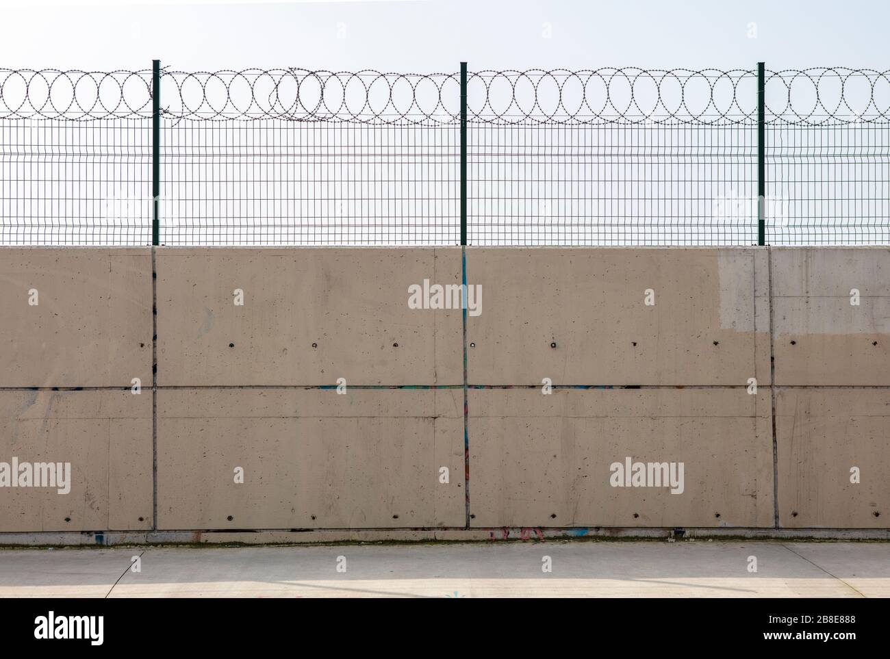 Razor wire with its sharp steel barbs on top of a concrete wall Stock ...