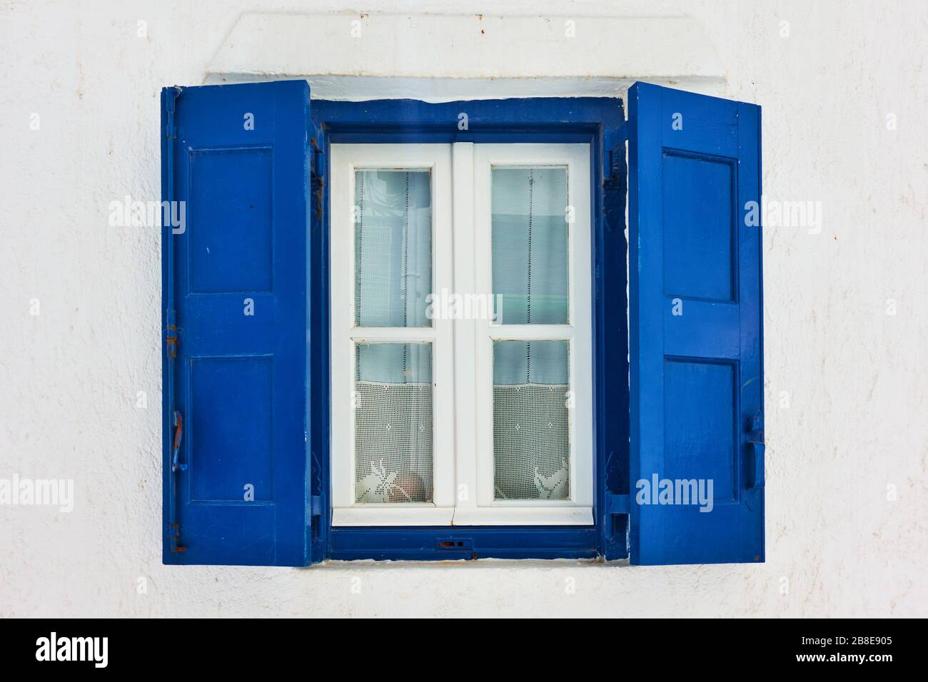 Window of greek whitewashed house with trditional blue shutters in ...