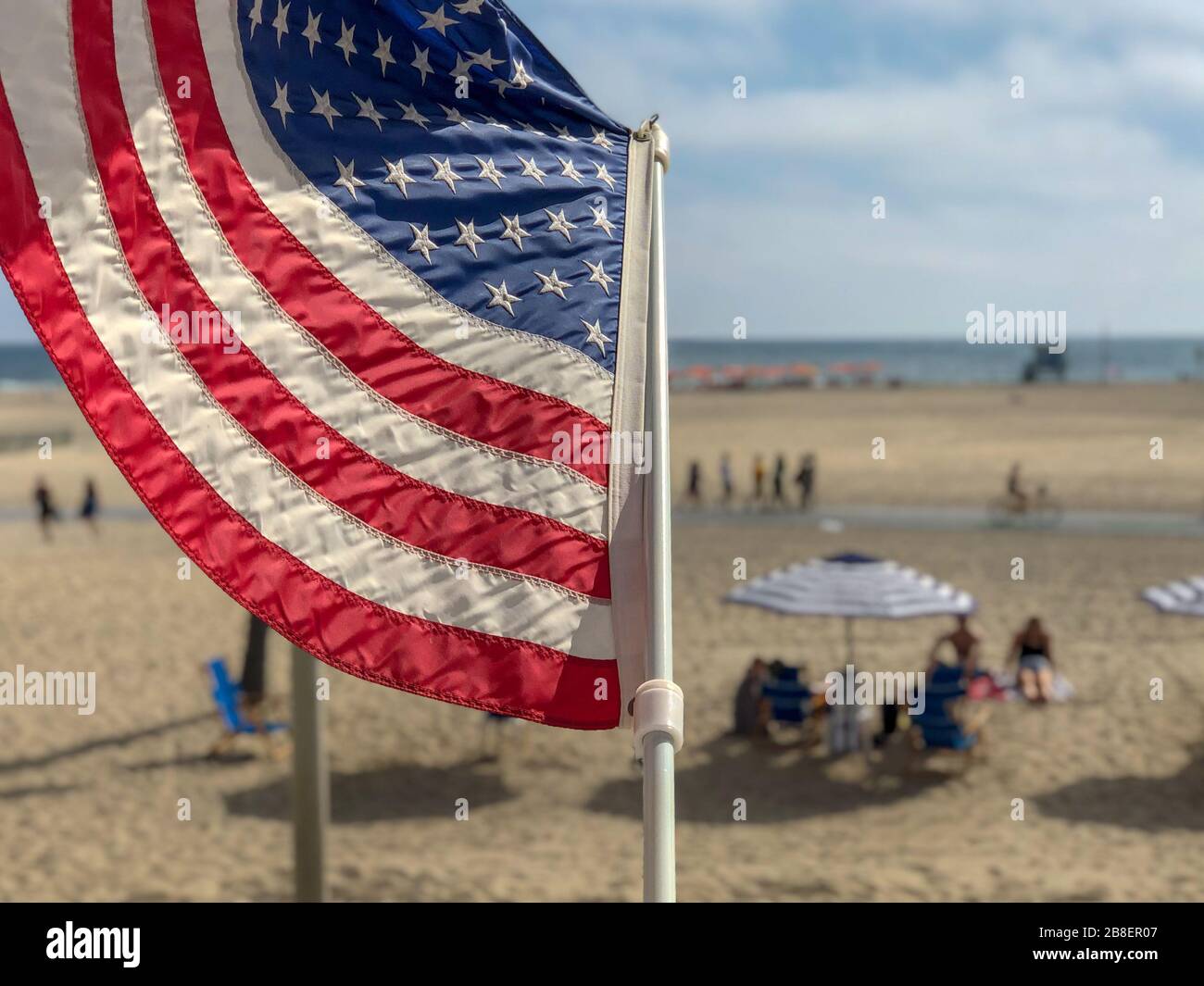 American flag with the beach on the background in Santa Monica beach ...
