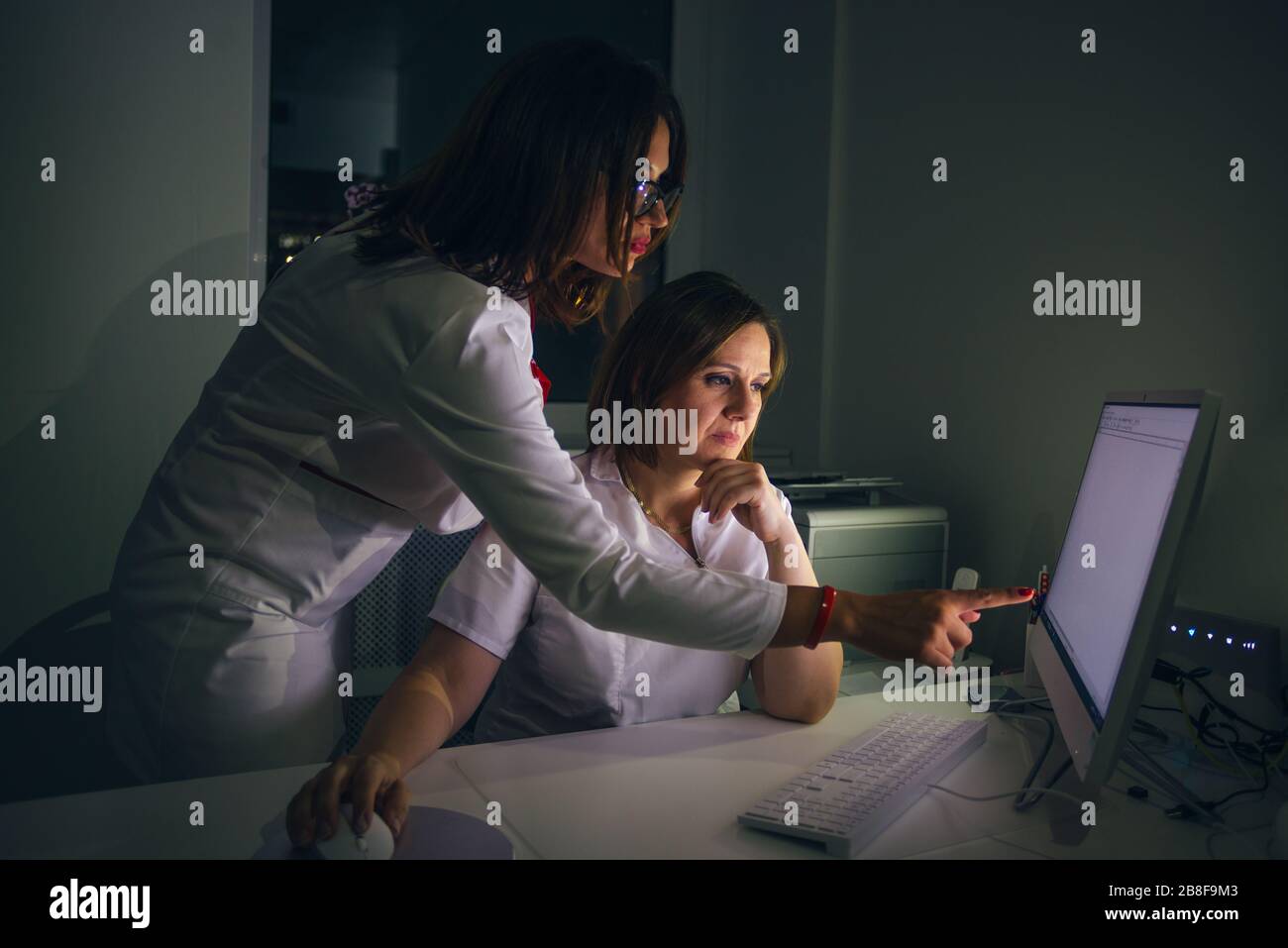 Female doctors ( medics ) work on a pc late at night Stock Photo - Alamy