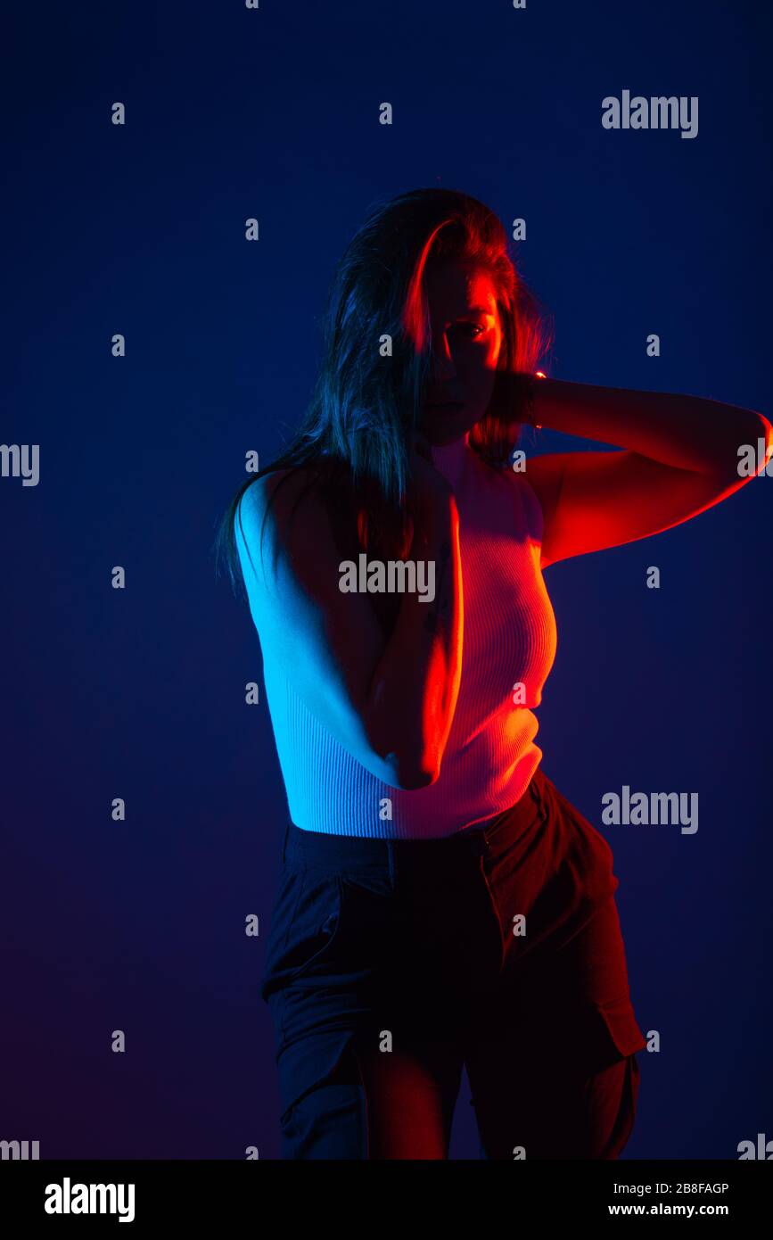 Female model posing in studio with red and blue colors at high contrast ...