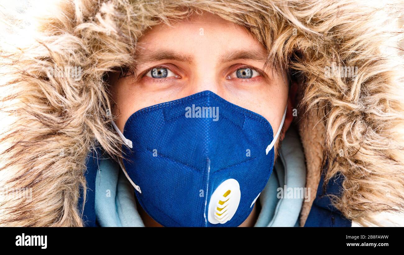 Closeup of man in hood wearing respirator N95 mask against ...