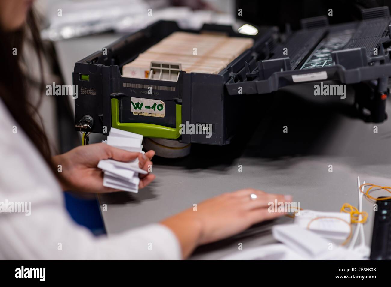 Accountant sorting vast amount of cash into a secure safety box used ...