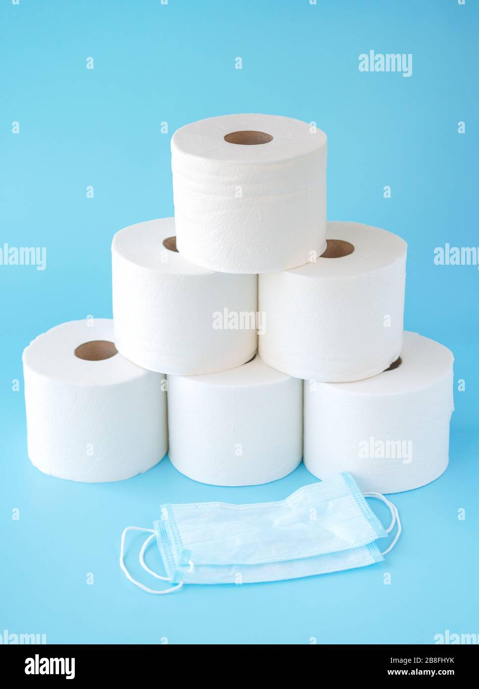 Toilet paper stacked rolls, medicine mask on a blue background.Toilet ...