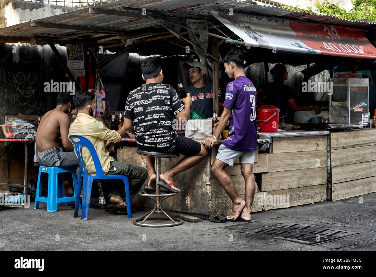 Alcohol drinking den. Group of young men drinking at a back street ...