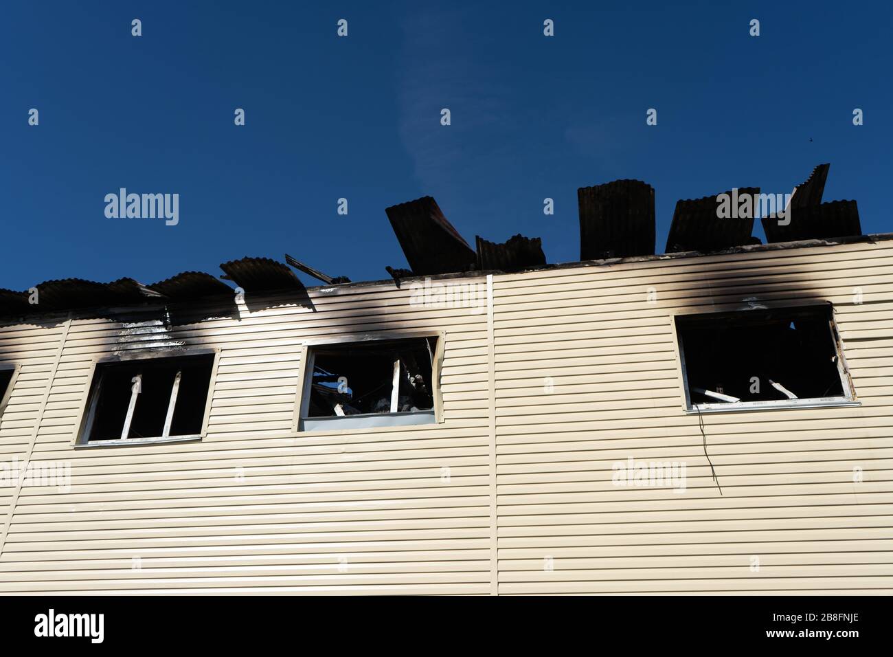 Burnt shop with a charred wall and broken windows. The consequences of ...