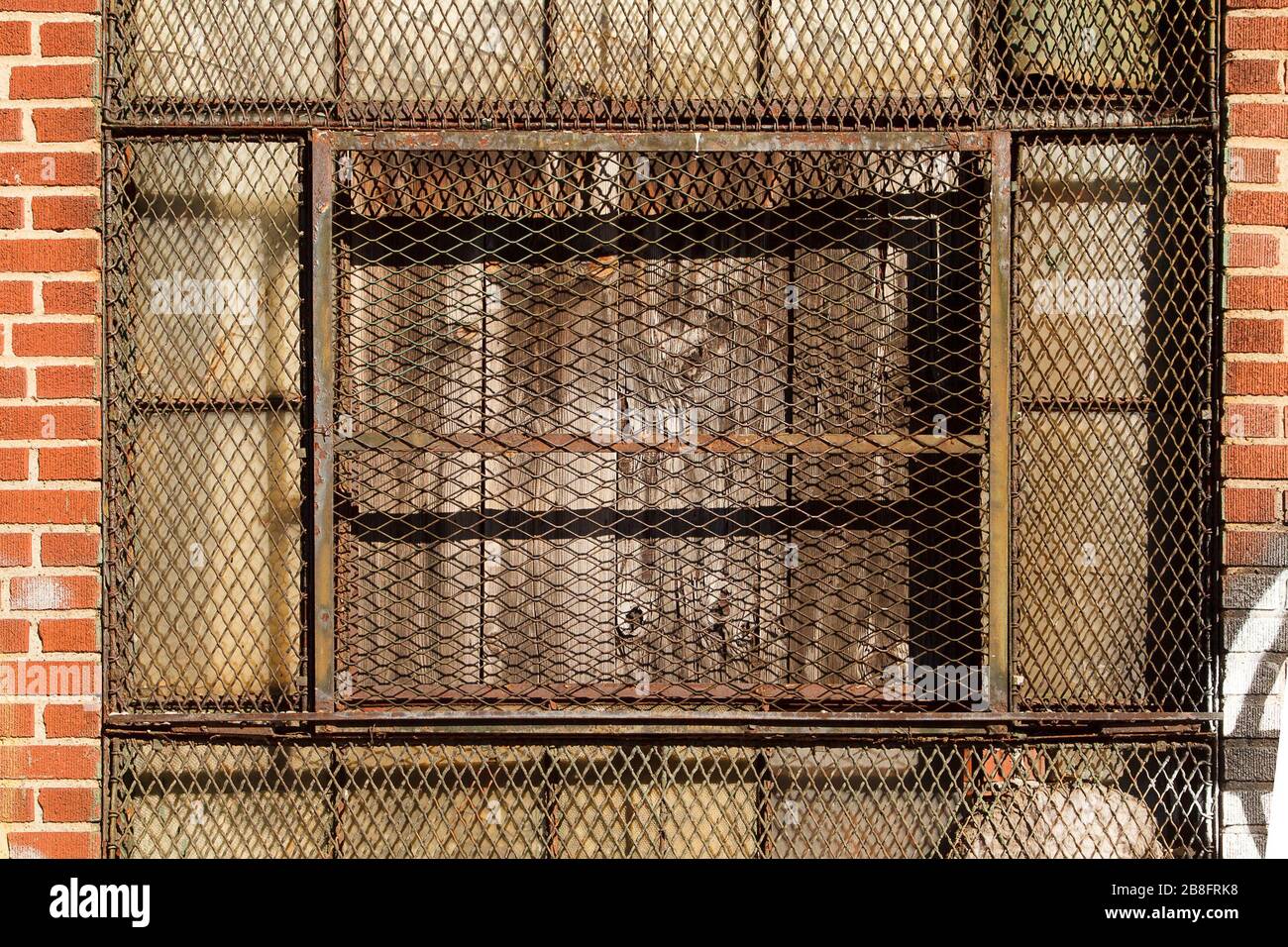 Steel mesh grating over boarded up window Stock Photo - Alamy