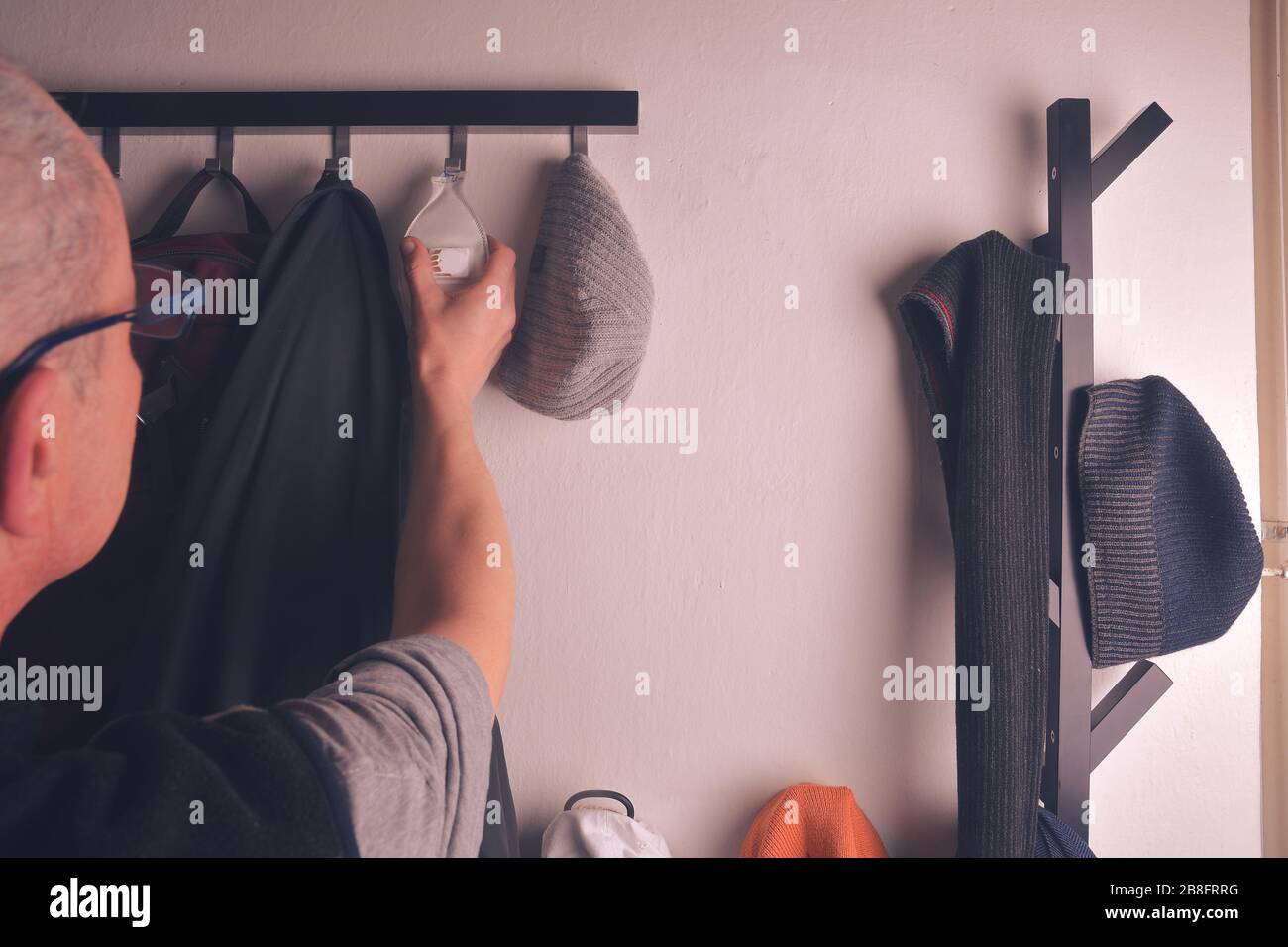 Man taking the respirator from peg. Going out with respirator ...