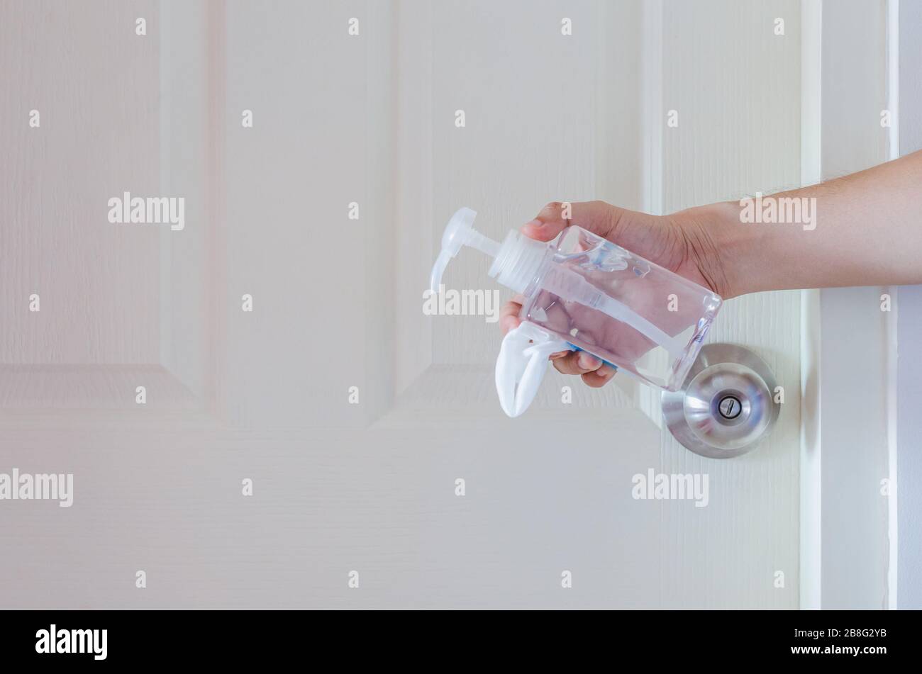 Hand holding a bottle of alcohol gel and wet alcohol tissue for home ...