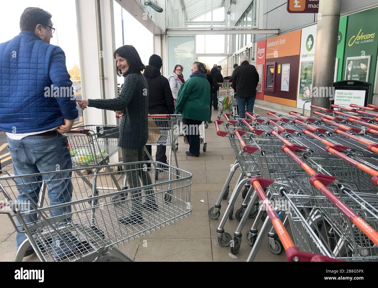 Shoppers queue outside the sainsburys supermarket at straiton hi-res ...