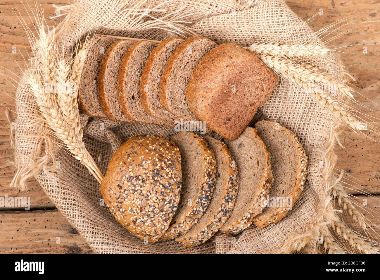 Rustic bread and wheat on an old vintage planked wooden table. Old wood ...