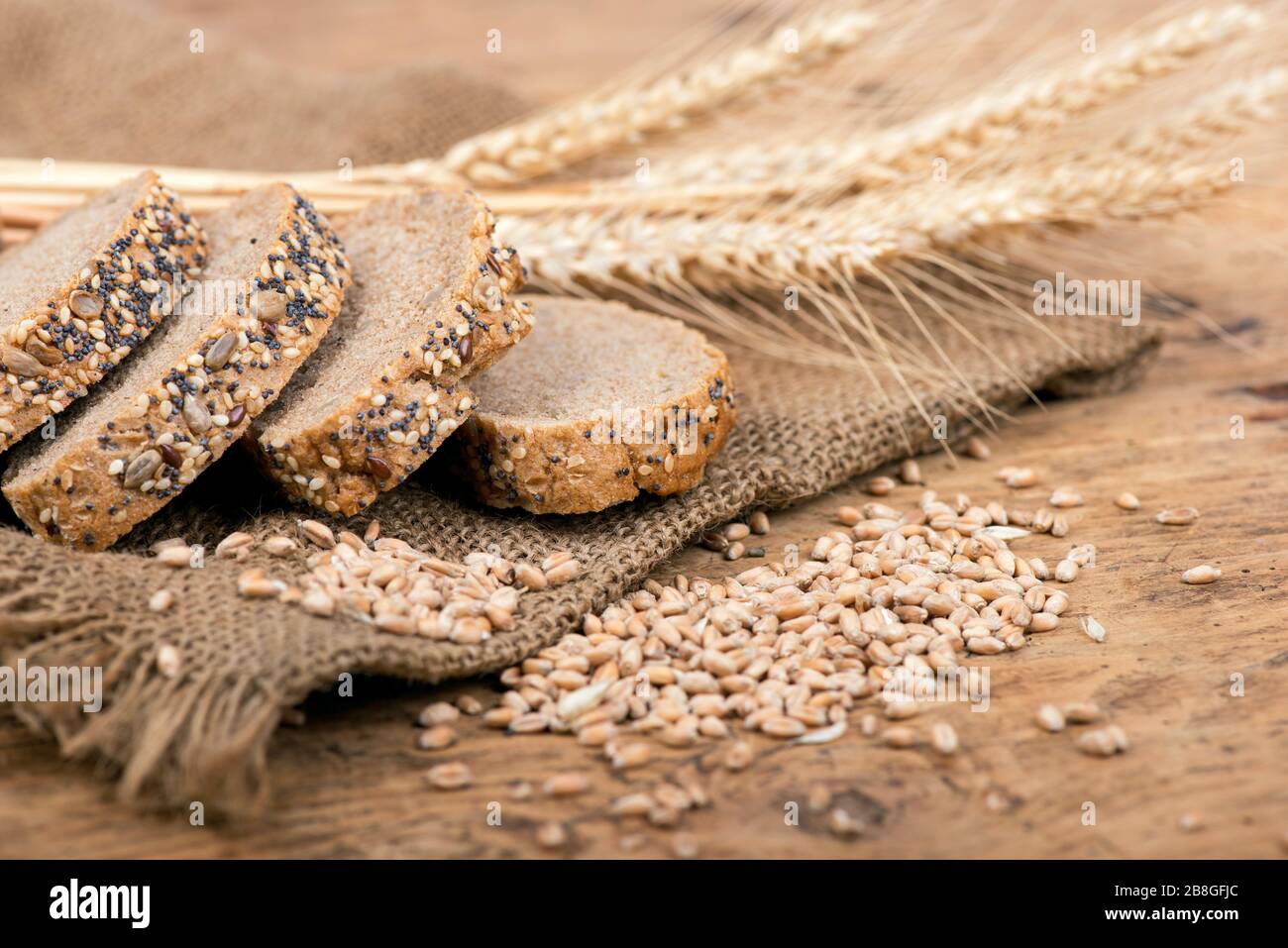 Rustic bread and wheat on an old vintage planked wooden table. Old wood ...