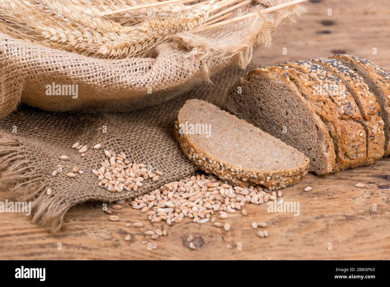 Rustic bread and wheat on an old vintage planked wooden table. Old wood ...
