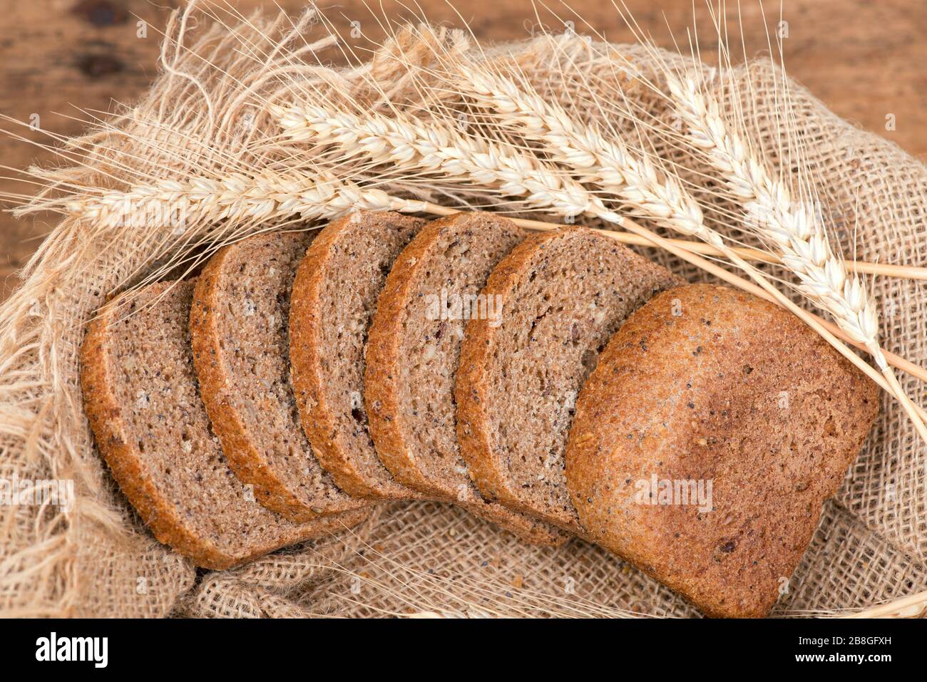 Rustic bread and wheat on an old vintage planked wooden table. Old wood ...
