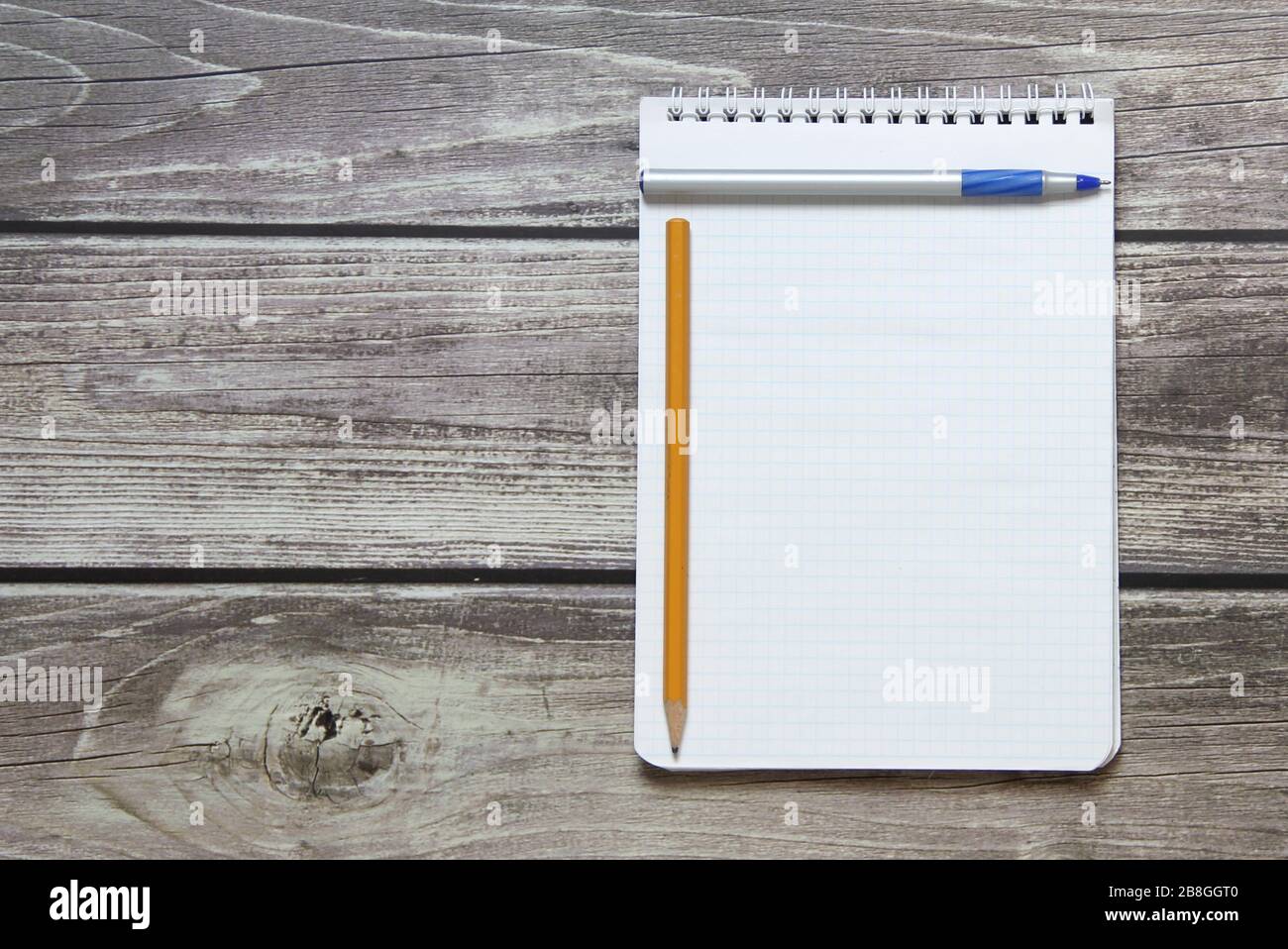Notepad with a blank white sheet in a checker paper with ball pen and ...