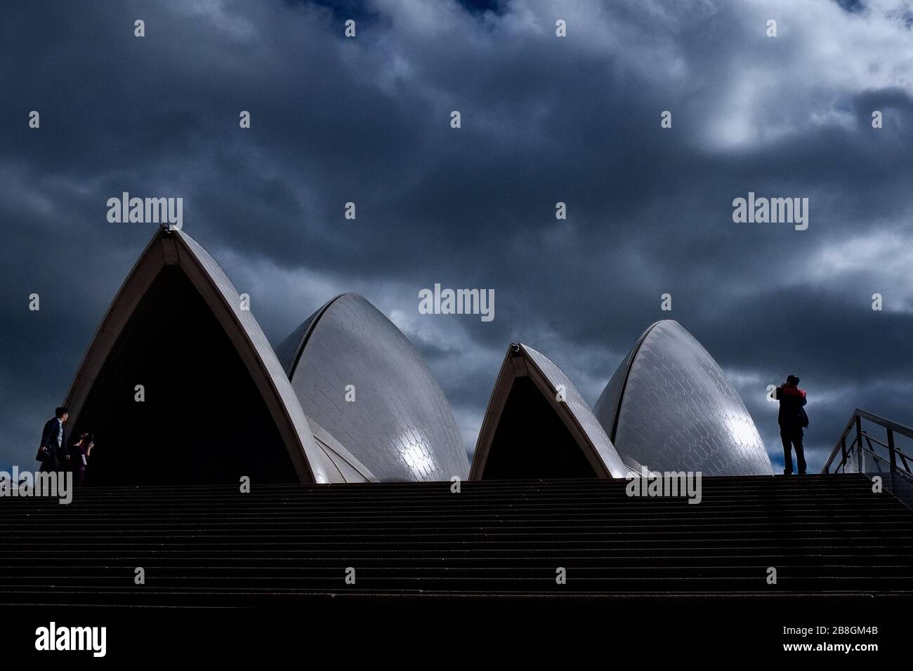 The epic design of the Sydney Opera House, tourists silhouetted at the ...
