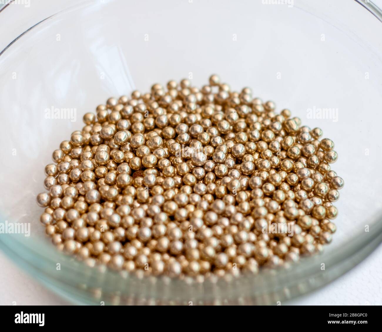 Close up of little golden balls in a clear transparent bowl Stock Photo ...