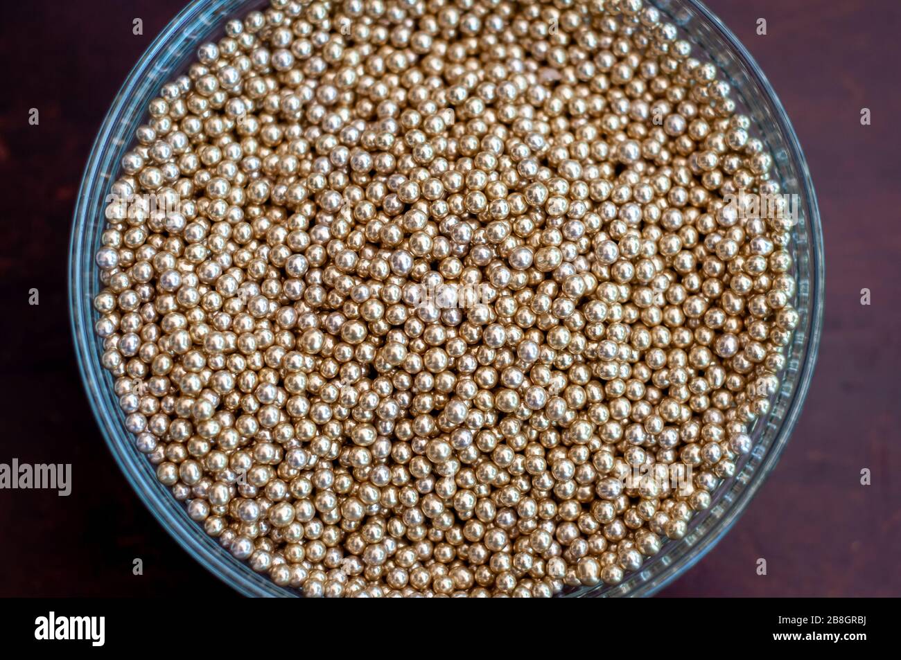 Close up of little golden balls in a clear transparent bowl Stock Photo ...
